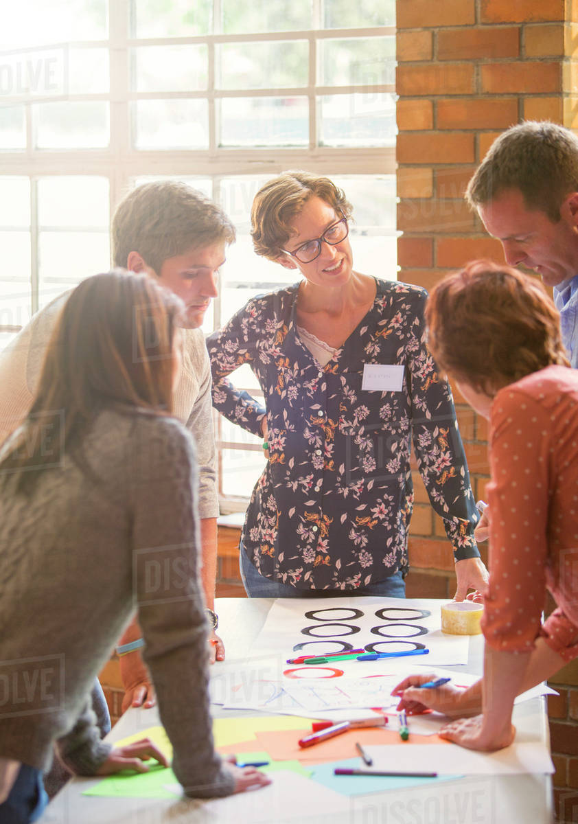 Creative business people reviewing proofs at table - Royalty-free Stock ...