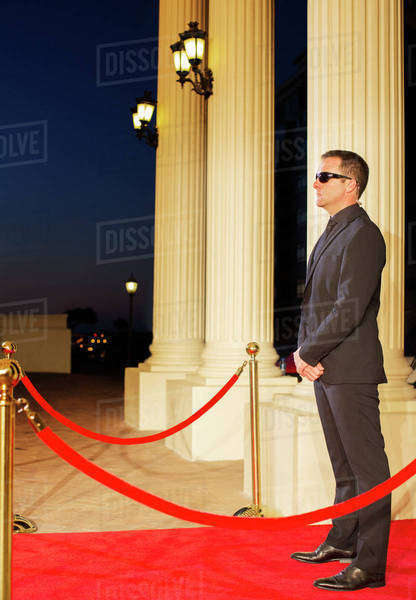 Serious bodyguard in sunglasses protecting red carpet at event ...