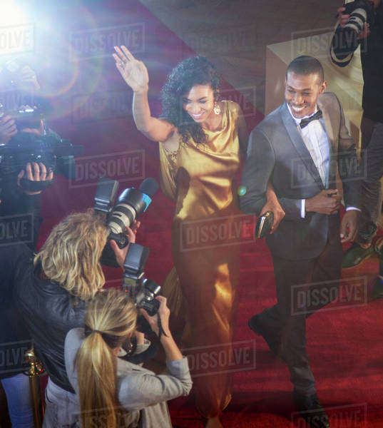 Celebrity couple waving and being photographed by paparazzi ...