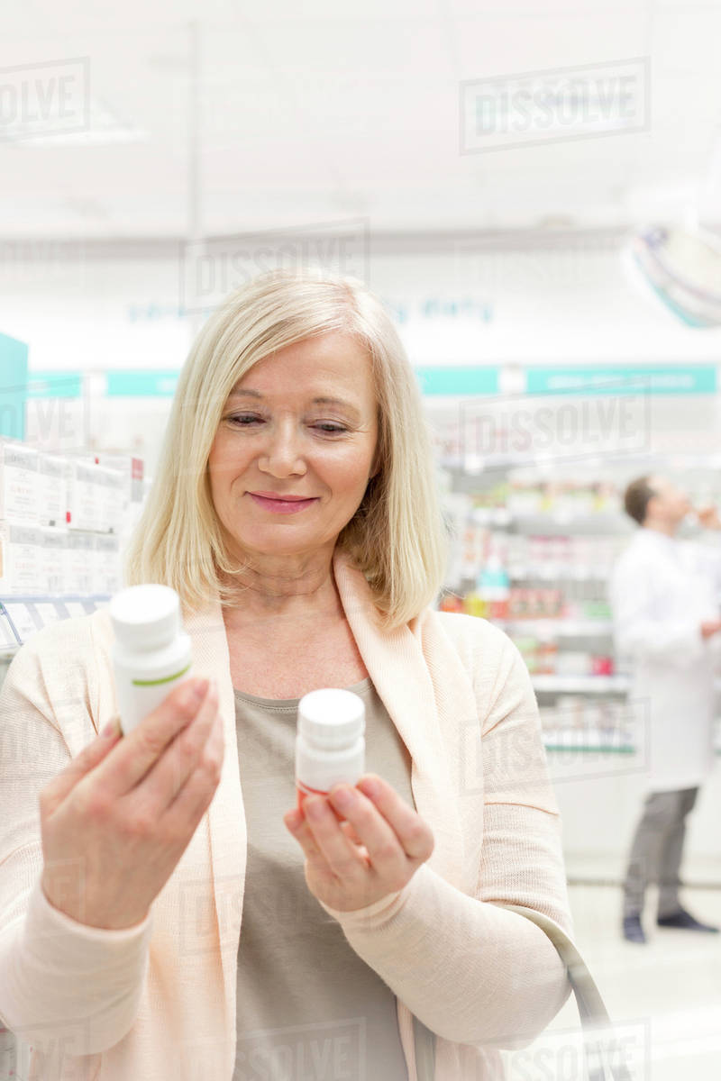 customer-reading-labels-on-bottles-in-pharmacy-stock-photo-dissolve