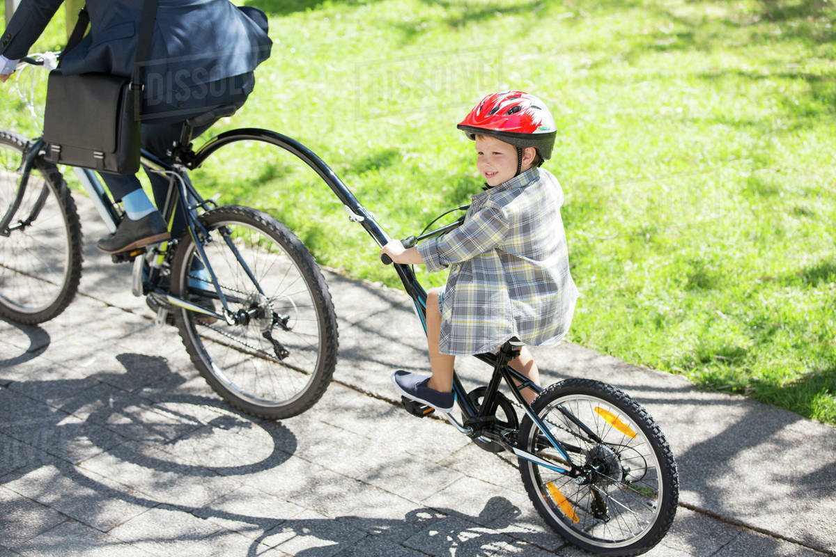 Boy riding tandem bicycle with businessman father in sunny park - Stock ...