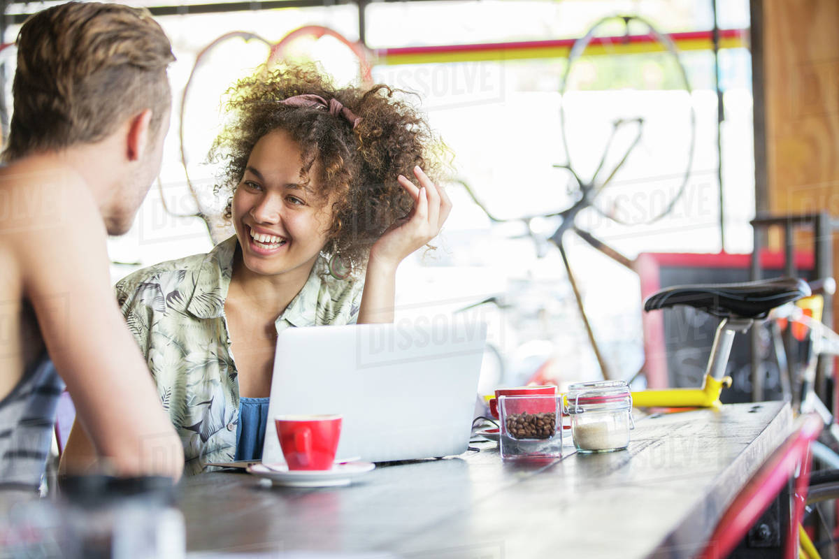 Couple talking at laptop in cafe - Stock Photo - Dissolve
