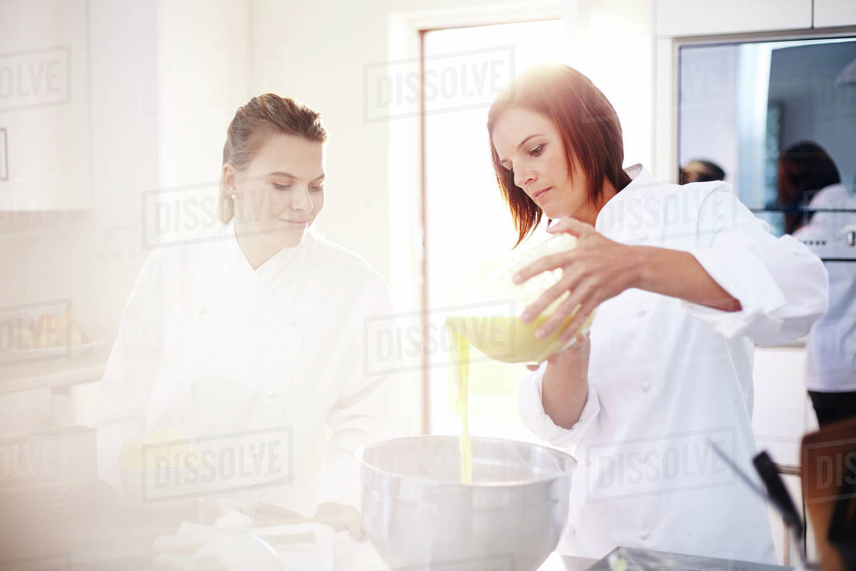Chefs baking pouring batter in bowl - Royalty-free Stock Photo | Dissolve