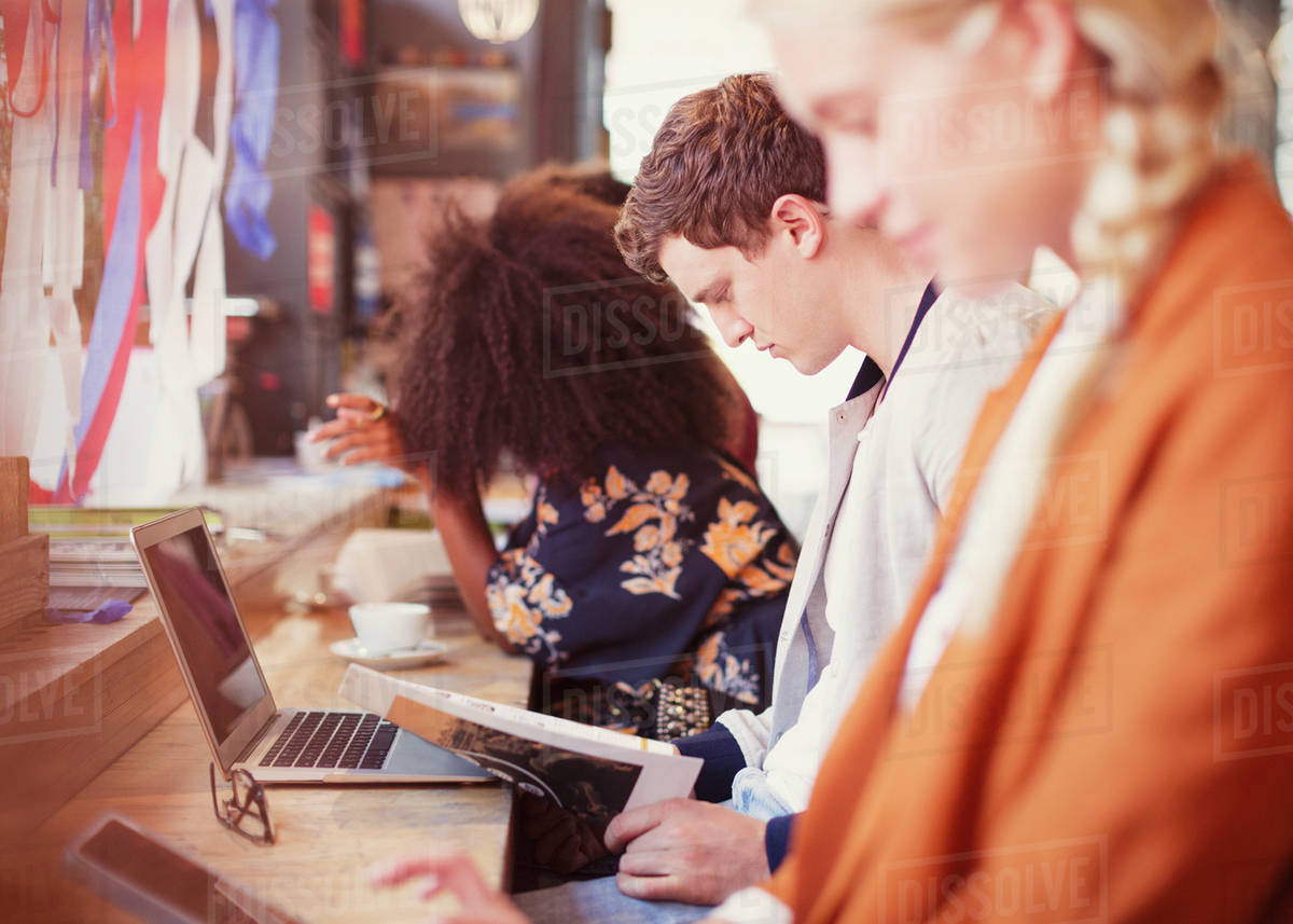 People working and drinking coffee in a row in cafe - Royalty-free ...