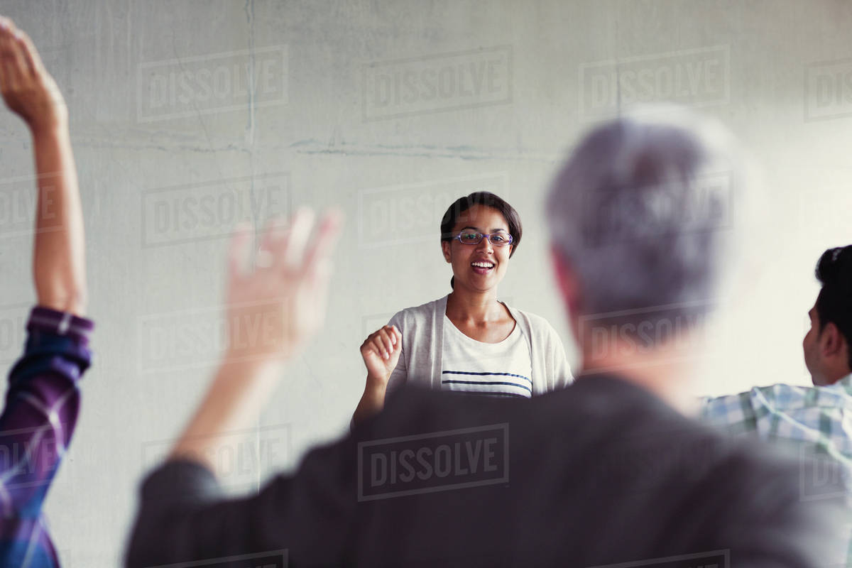 Teacher calling on students with hands raised in adult education ...
