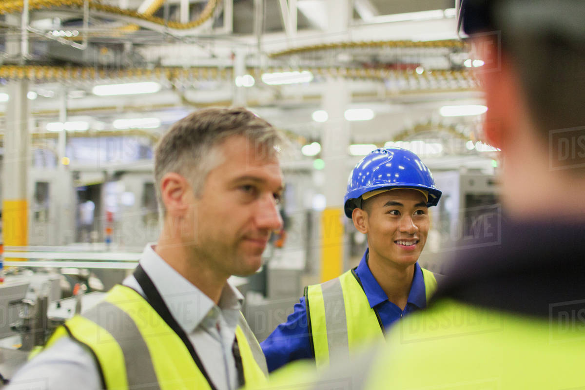 Workers talking in factory - Royalty-free Stock Photo | Dissolve