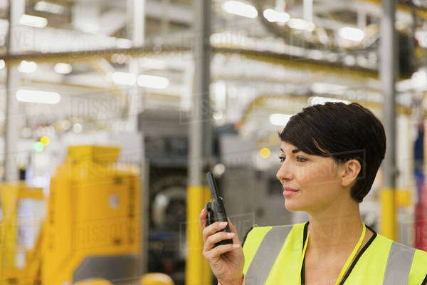 Worker using walkie-talkie in factory - Stock Photo - Dissolve