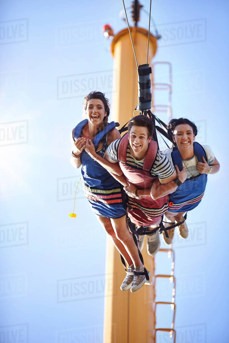 Portrait smiling friends bungee jumping at amusement park - Royalty ...