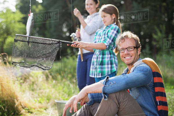 Family fishing together in tall grass - Royalty-free Stock Photo | Dissolve