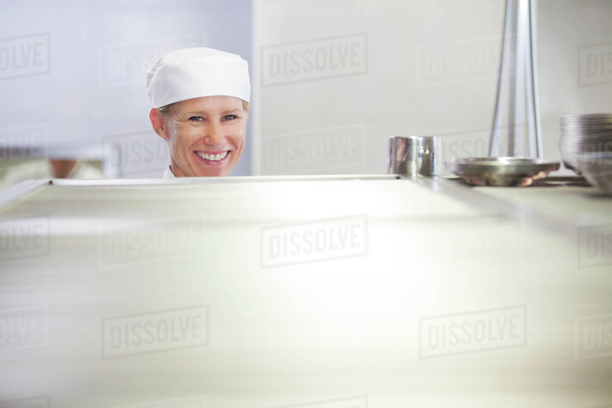 Chef smiling in restaurant kitchen - Royalty-free Stock Photo | Dissolve