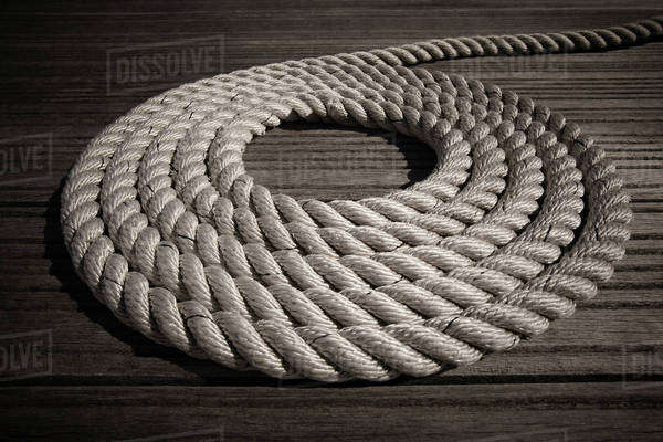 Rope coiled in circle on boardwalk - Royalty-free Stock Photo | Dissolve