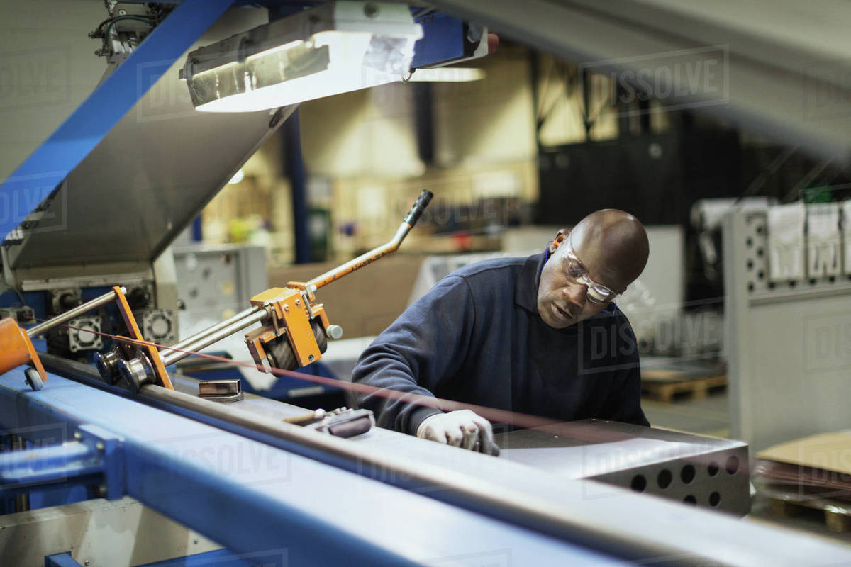 Worker operating machinery in steel factory - Stock Photo - Dissolve