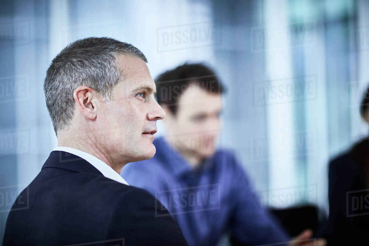 Attentive businessman listening in meeting - Stock Photo - Dissolve