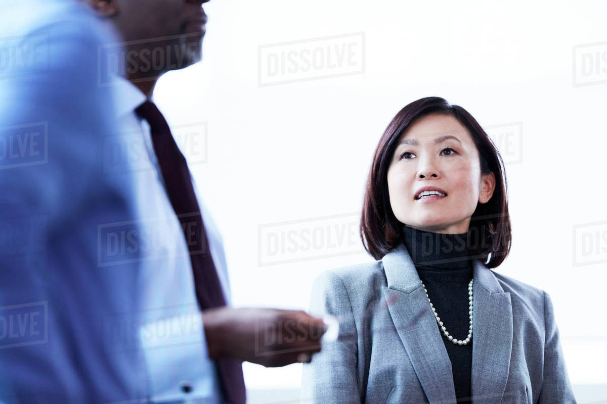 Businesswoman talking to colleague - Royalty-free Stock Photo | Dissolve