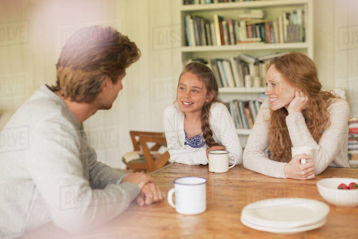 Family drinking tea and talking at dining table - Royalty-free Stock ...