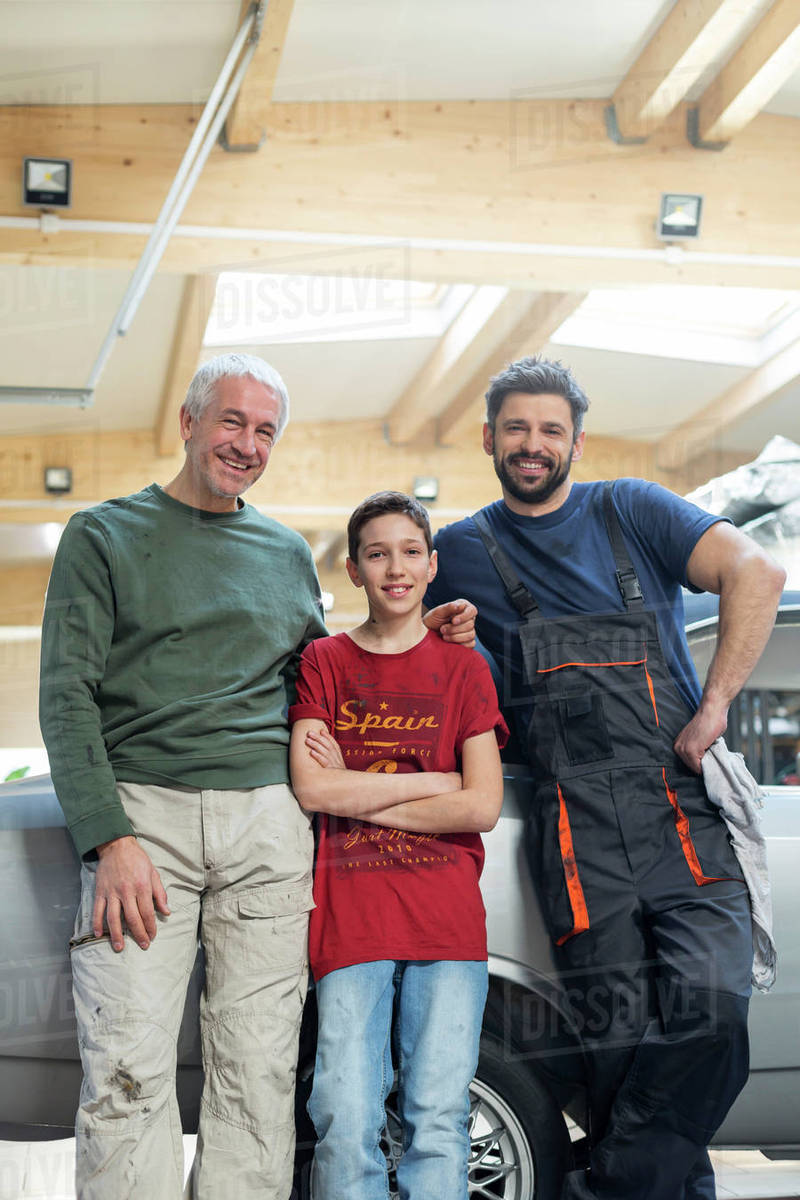 Portraits smiling multi-generation mechanic family in auto repair shop ...