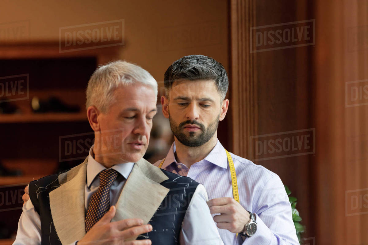 Tailor fitting businessman for suit in menswear shop - Royalty-free ...