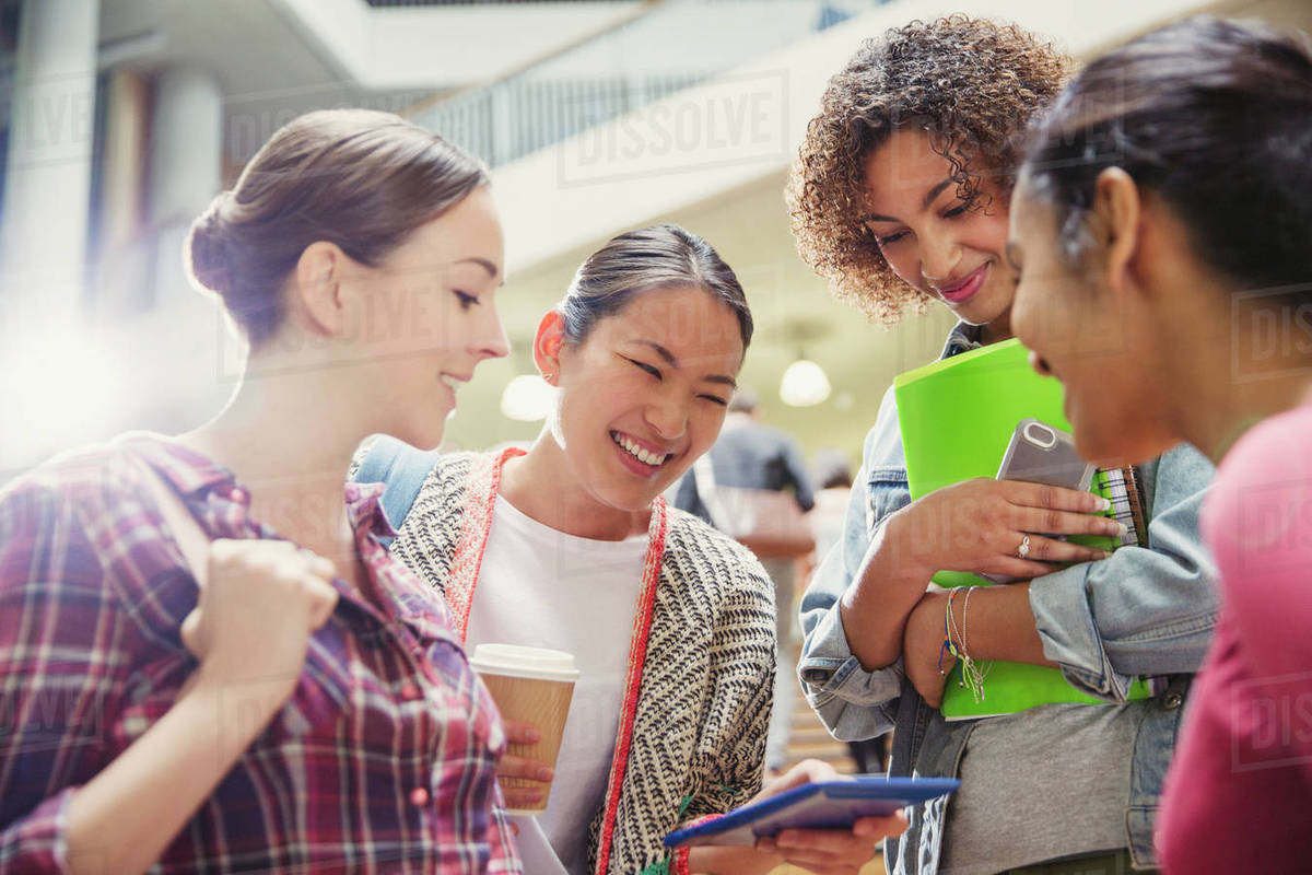 College students looking at cell phone - Stock Photo - Dissolve