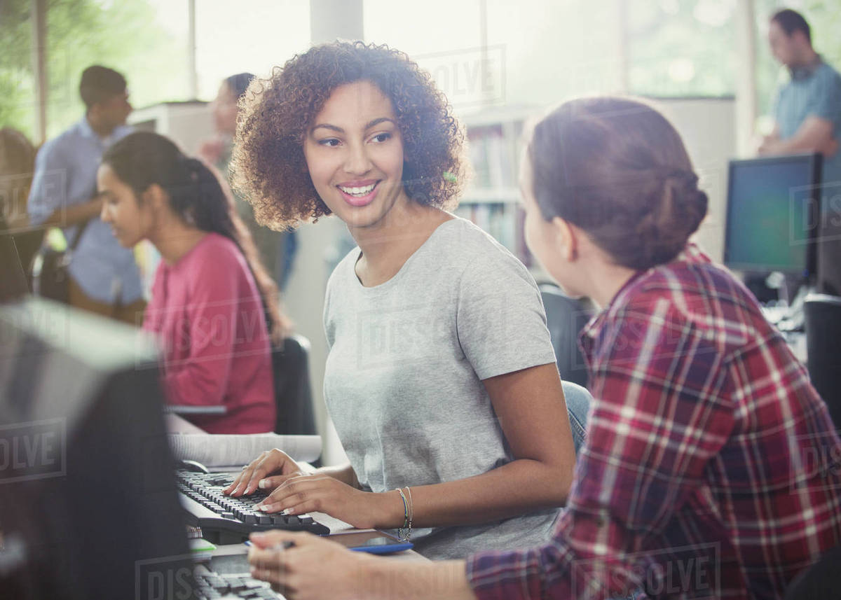 Female college students using computers in computer lab library ...