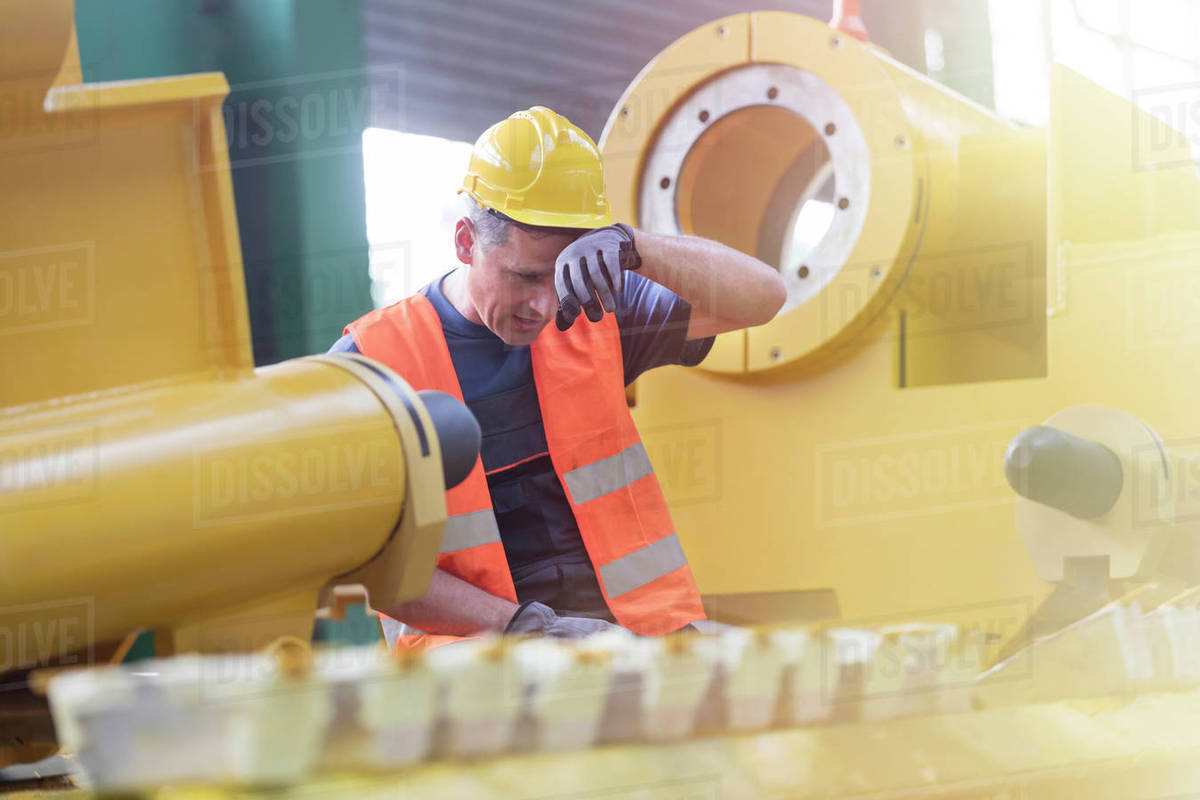 Tired steel worker in factory - Royalty-free Stock Photo | Dissolve