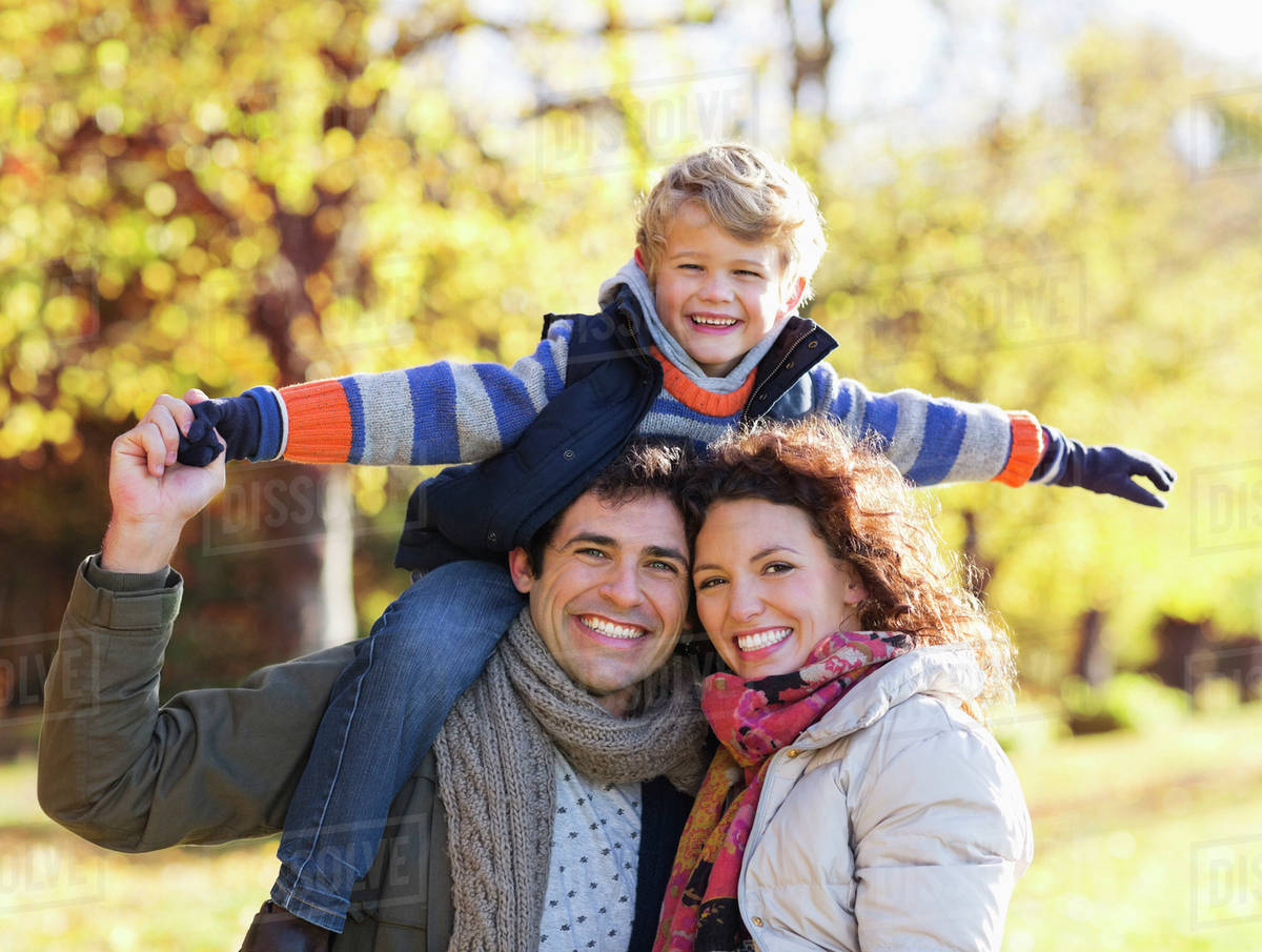 Family smiling together in park - Royalty-free Stock Photo | Dissolve
