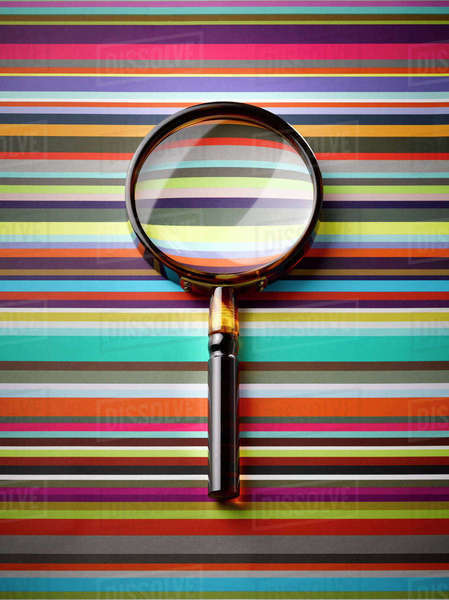 Magnifying glass on striped background - Stock Photo - Dissolve