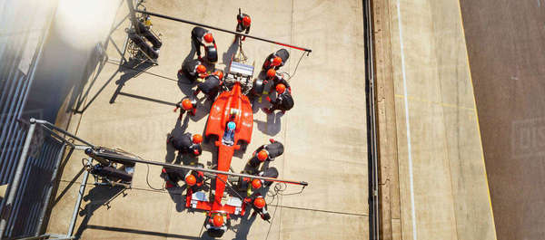 Overhead pit crew working on formula one race car in pit lane - Royalty ...