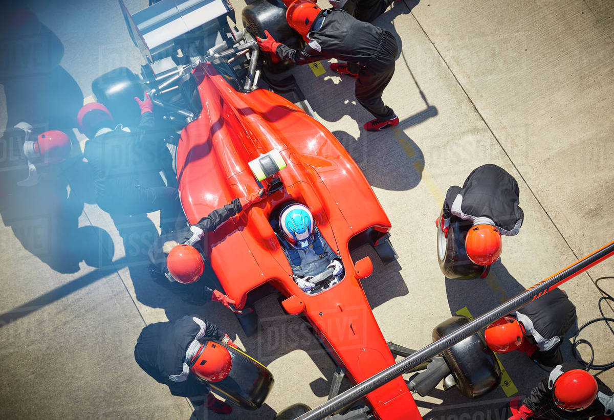 Overhead pit crew working on formula one race car in pit stop - Royalty ...