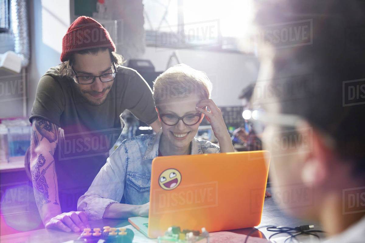 Designers working at laptop in workshop - Stock Photo - Dissolve