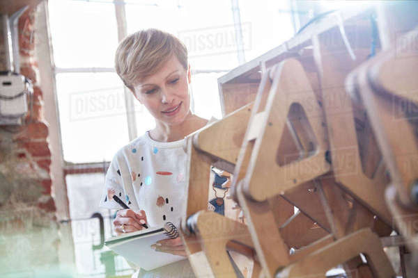 Female designer examining prototype and taking notes - Stock Photo ...
