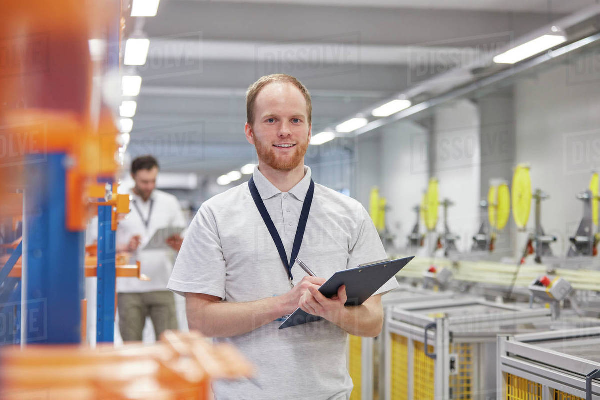 Portrait smiling, confident male supervisor with clipboard in fiber ...
