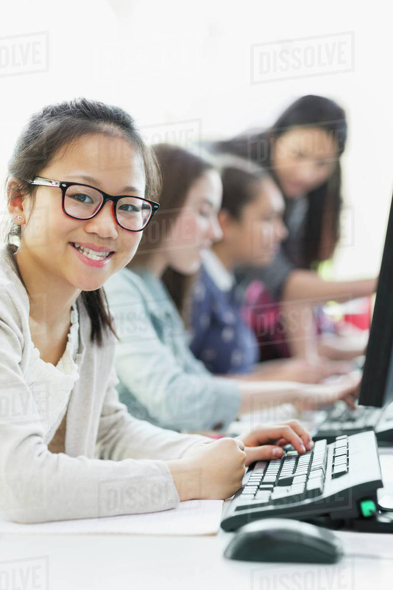 Portrait smiling girl student using computer in computer lab - Royalty ...