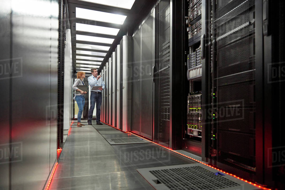 IT technicians talking at panel in server room - Royalty-free Stock ...