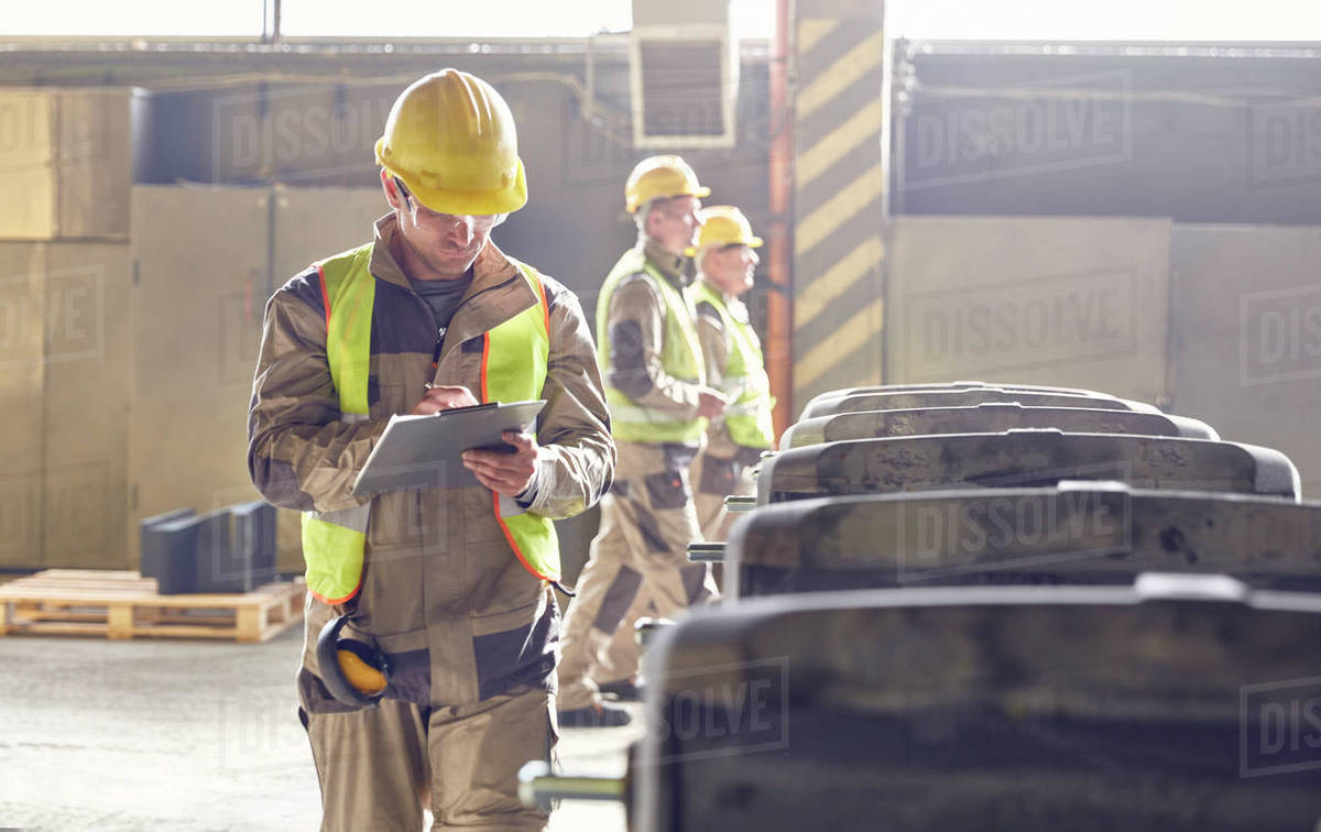 Steelworker writing on clipboard in steel mill - Royalty-free Stock ...
