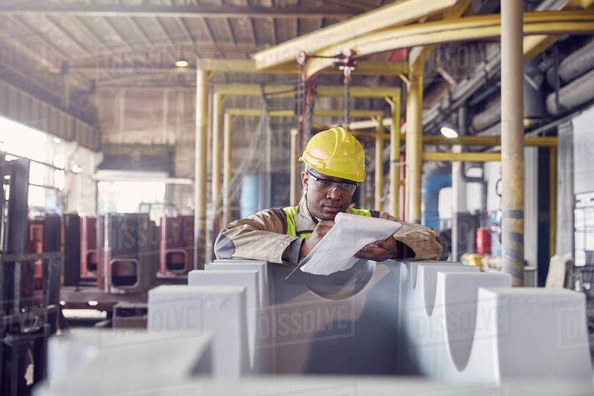Steelworker with clipboard in steel mill - Stock Photo - Dissolve