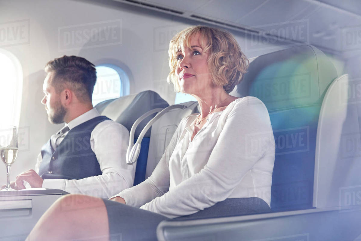 Businesswoman sitting in first class on airplane - Royalty-free Stock ...