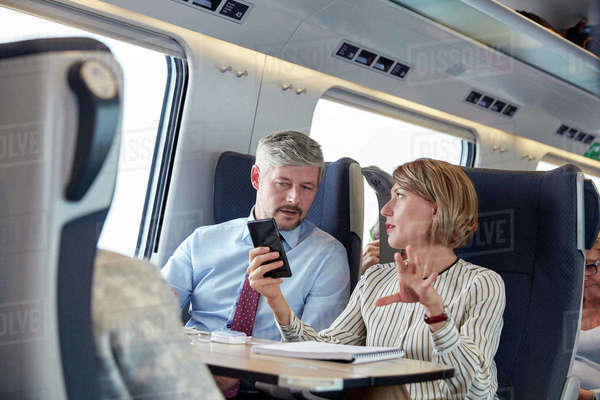 Business people working, using smart phone and talking on passenger ...