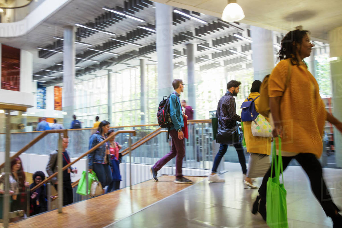 Business people ascending stairs at conference - Stock Photo - Dissolve