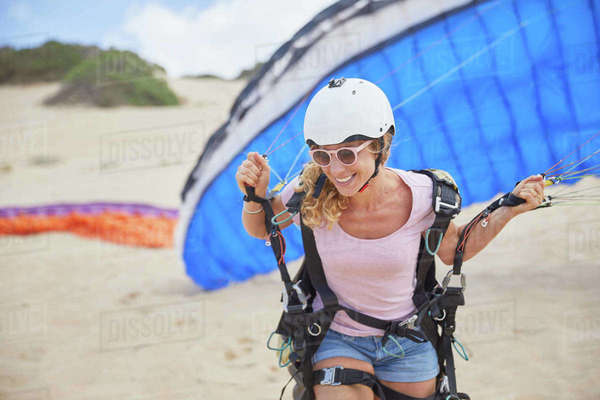 Smiling female paraglider with parachute on beach - Royalty-free Stock ...