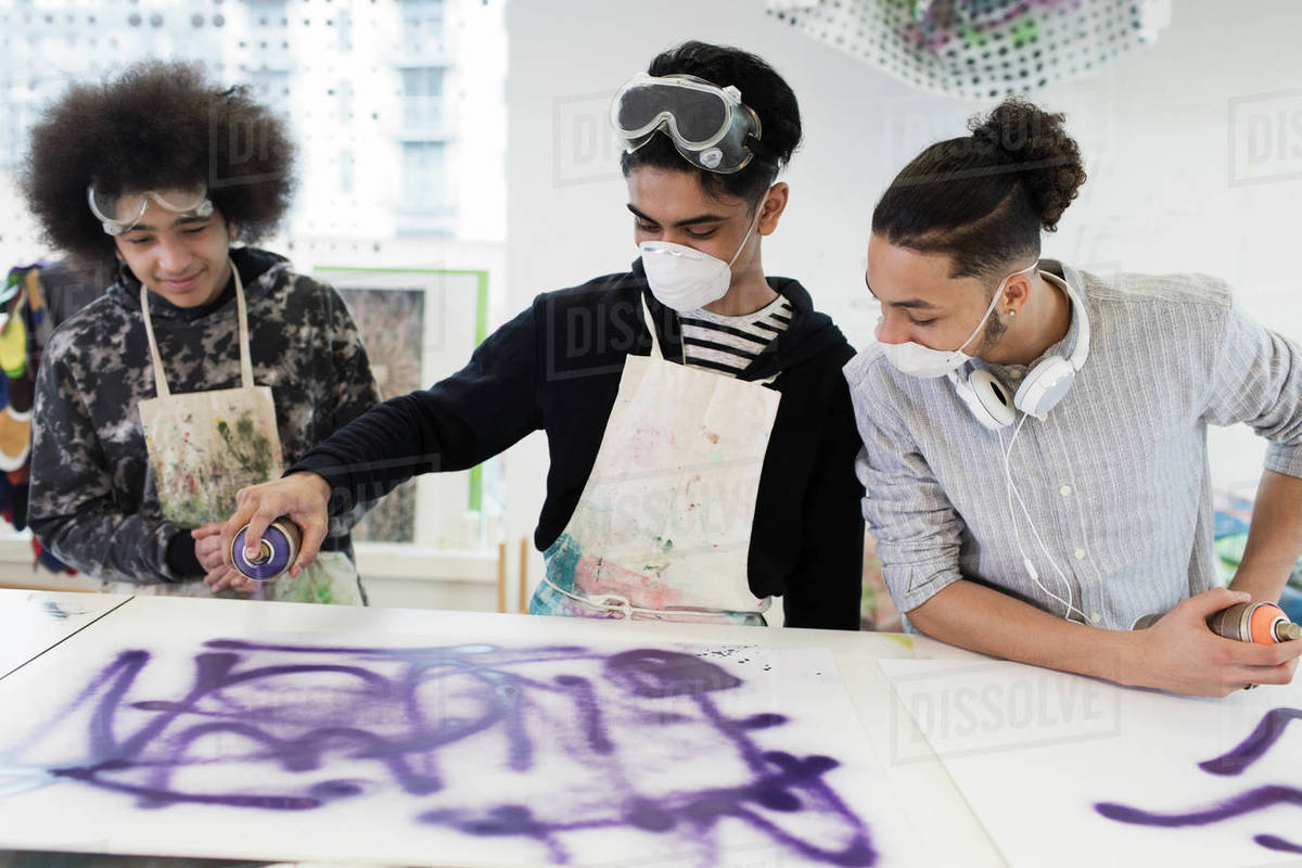 Teenage boys spray painting in high school art class - Stock Photo ...