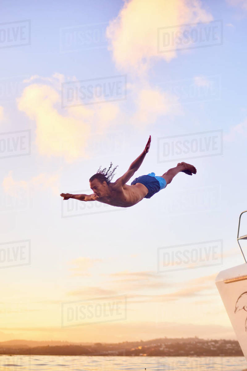 Young man diving into ocean - Royalty-free Stock Photo | Dissolve