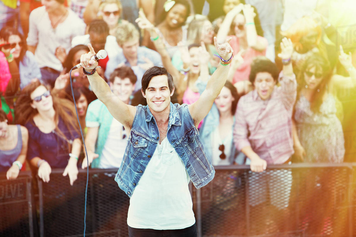 Portrait of performer with fans in background at music festival - Stock ...