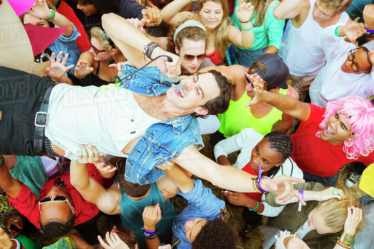 Performer with microphone crowd surfing at music festival - Royalty ...