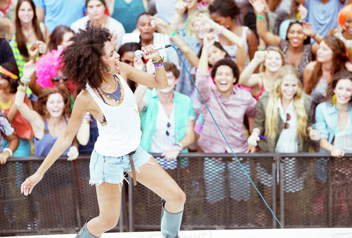 Fans cheering for performer singing on stage at music festival - Stock ...