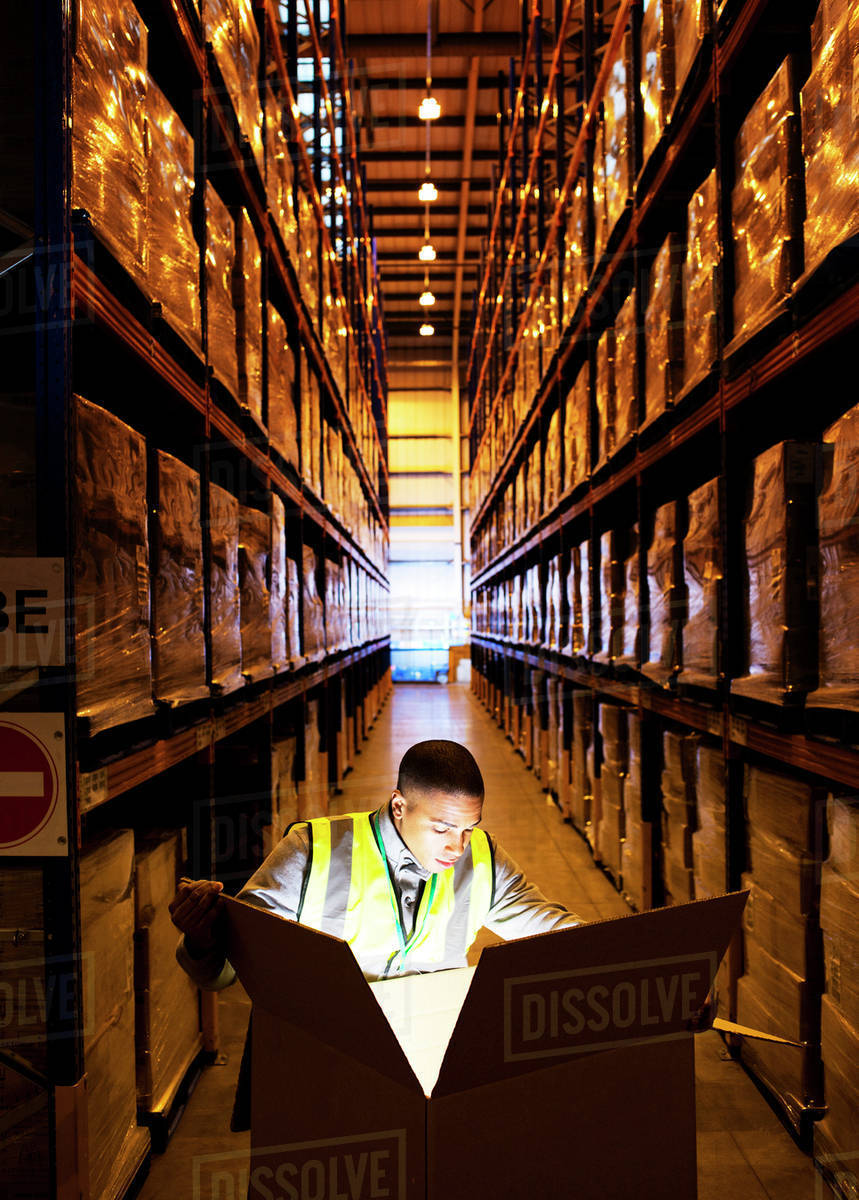 Worker opening glowing box in warehouse - Royalty-free Stock Photo ...