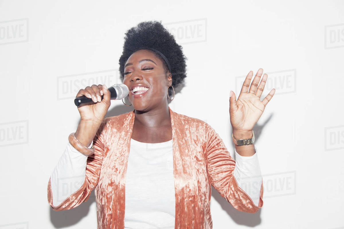 Woman singing with microphone - Royalty-free Stock Photo | Dissolve
