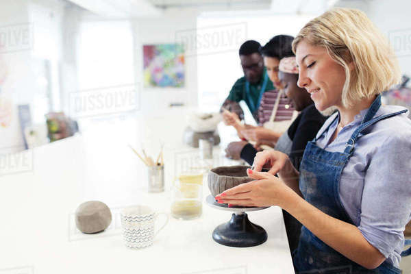Woman making clay bowl in art class - Stock Photo - Dissolve