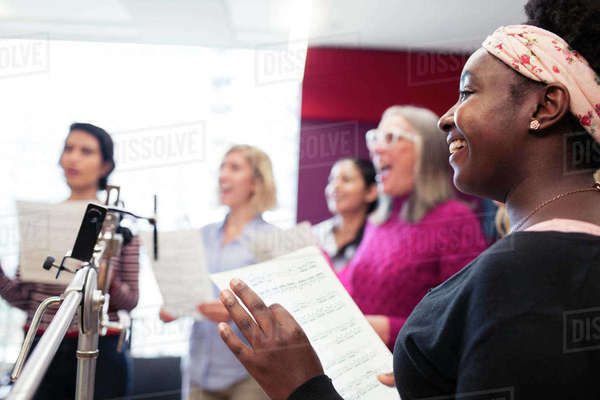 Womens choir with sheet music singing in music recording studio ...