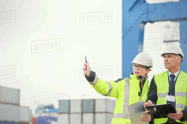 Dock worker and manager with clipboard talking at shipyard - Royalty ...