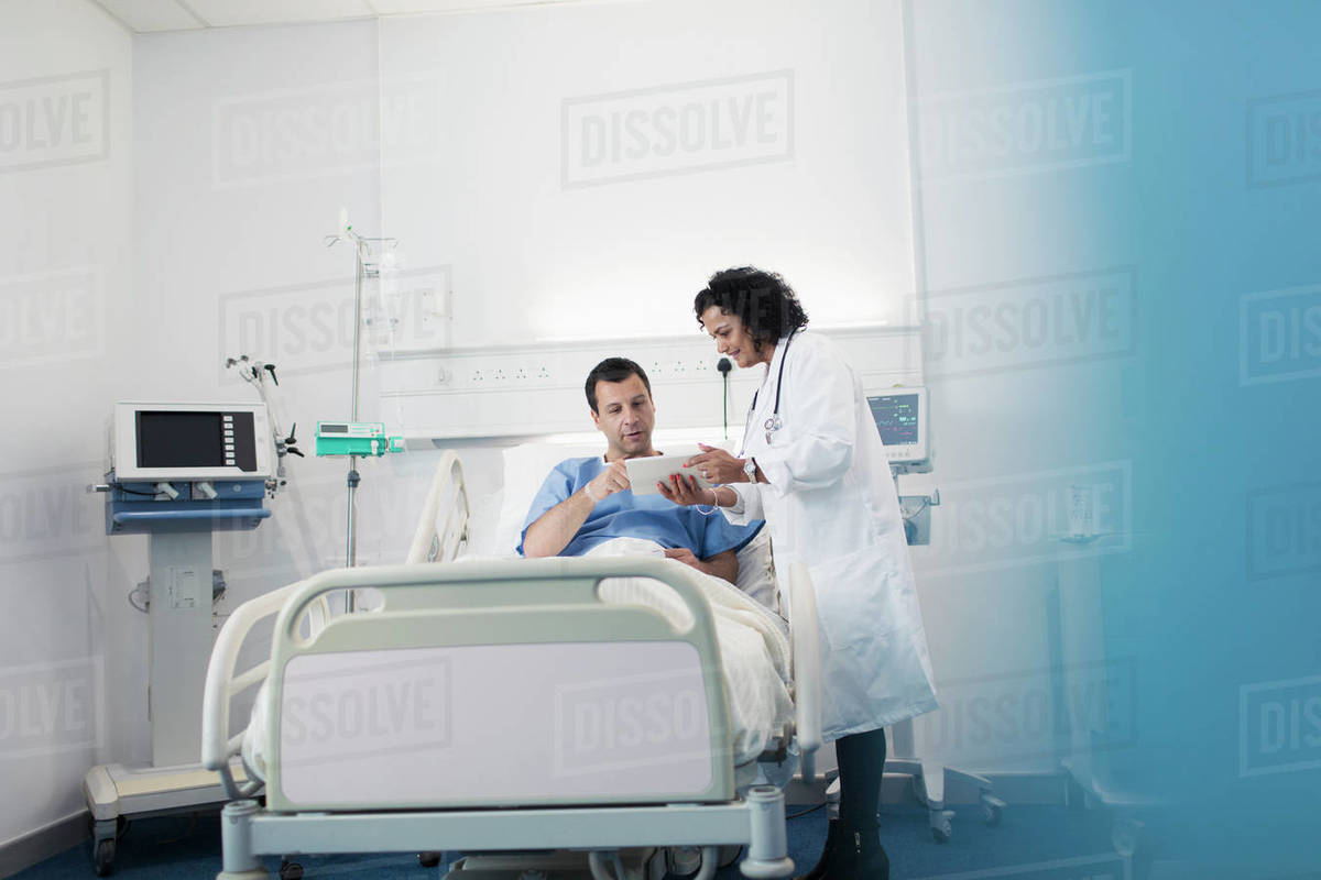 Doctor with digital tablet making rounds, talking with patient resting ...